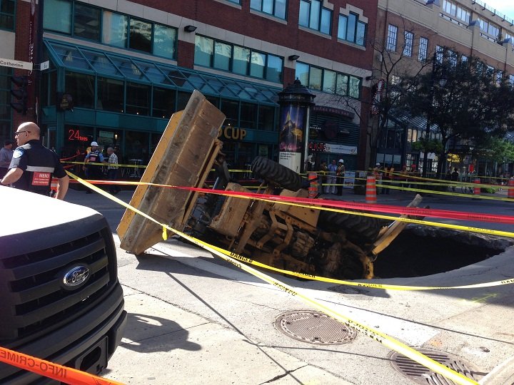 Sinkhole swallows backhoe in downtown Montreal | Globalnews.ca