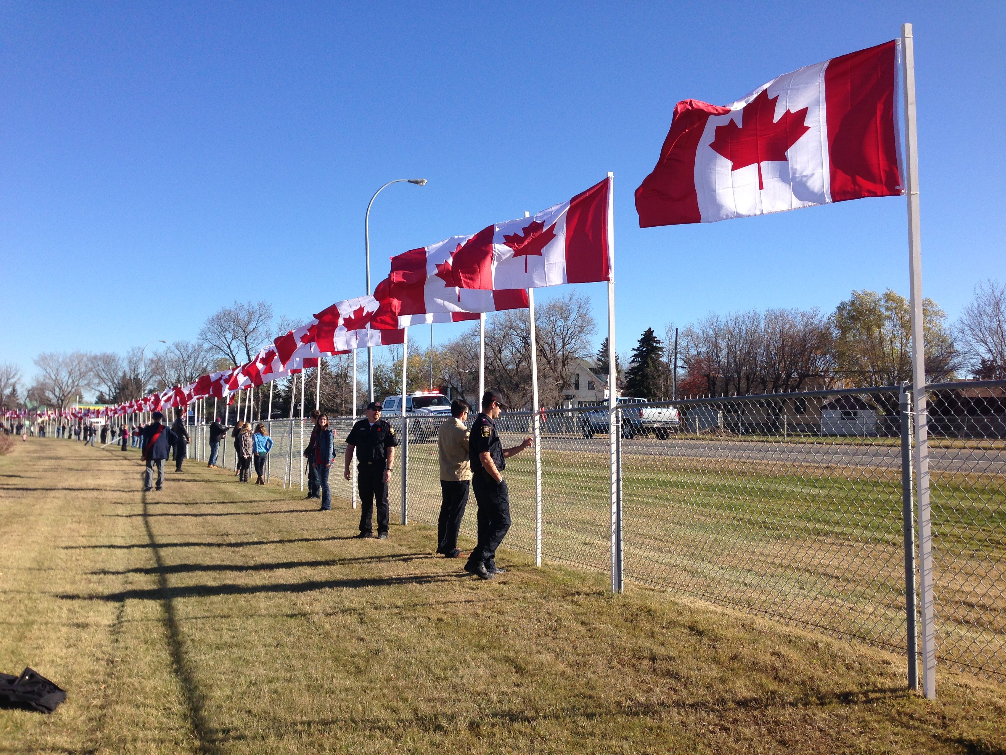 128 Canadian flags raised at same time across country for war dead ...