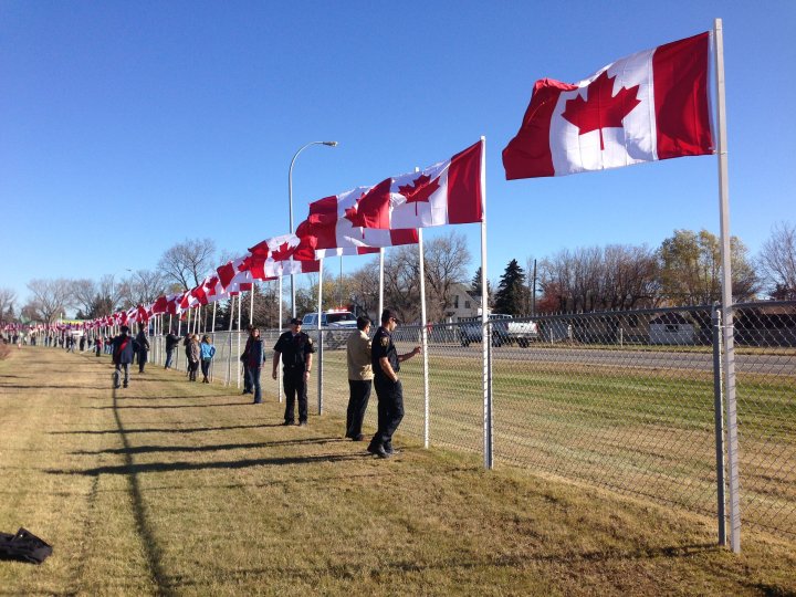 128 Canadian flags raised at same time across country for war dead ...